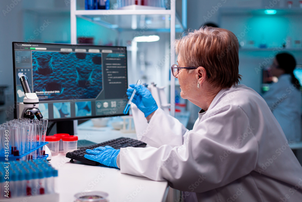 Biotechnologist senior scientist researching with test tube in pharma ...