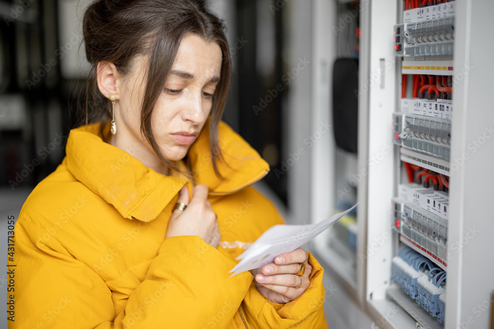 Confused woman looks at electricity bills, comparing data with the ...