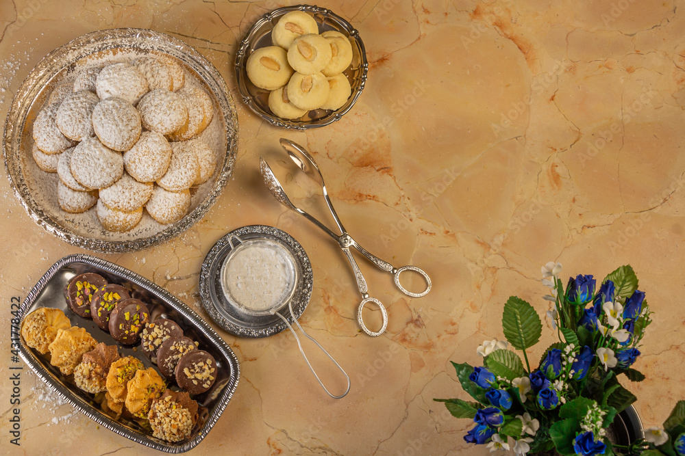 Different types of Eid Al fitr cookies presented in silver plates ...