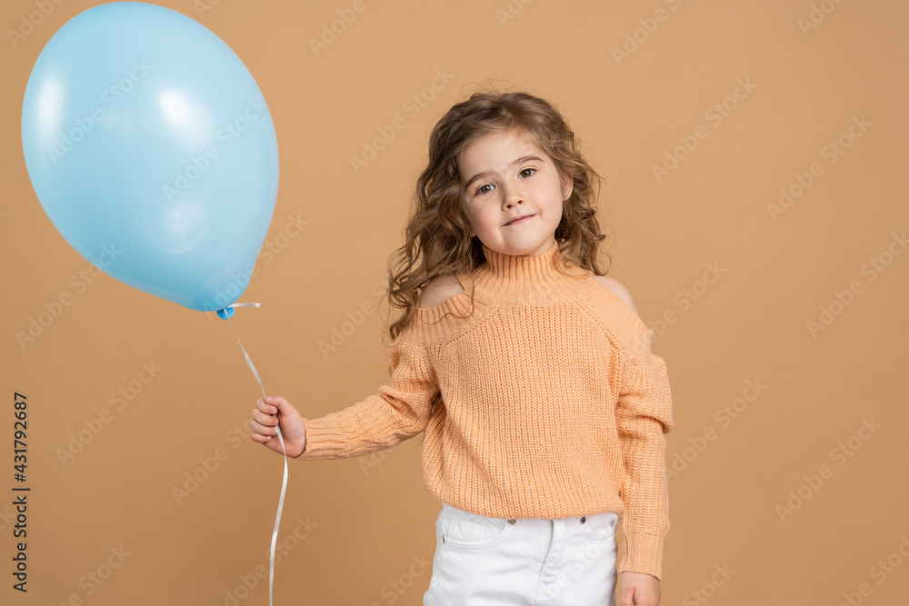 Very cute, attractive, little girl with a balloon on a brown background ...