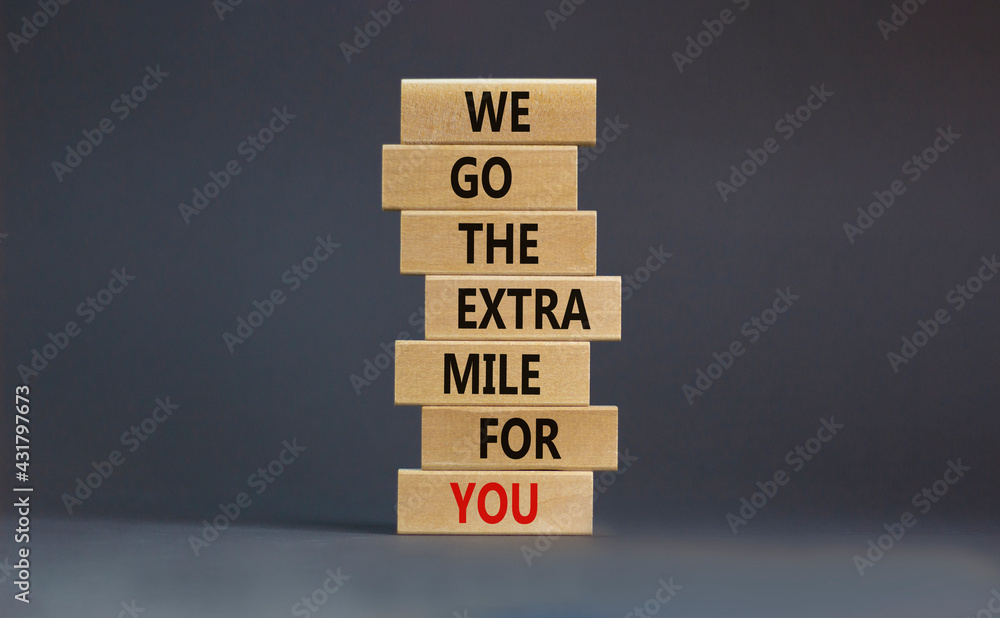 Go the extra mile symbol. Wooden blocks with words 'We go the extra ...