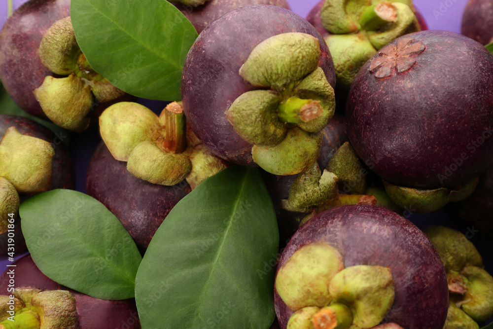 Delicious fresh mangosteen fruits with leaves as background, closeup ...