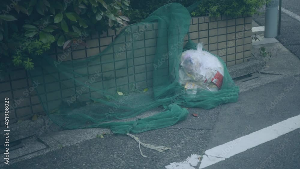 Trash on curb of sidewalk with road in background on city street. Stock ...