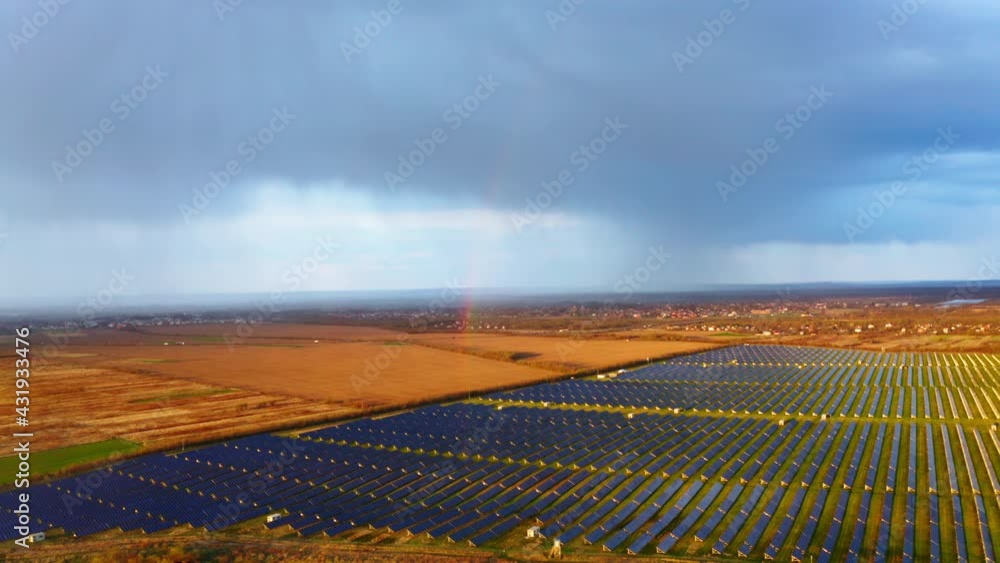 Rainbow in the sky above a Solar Panels Farm with Storm clouds. Aerial ...