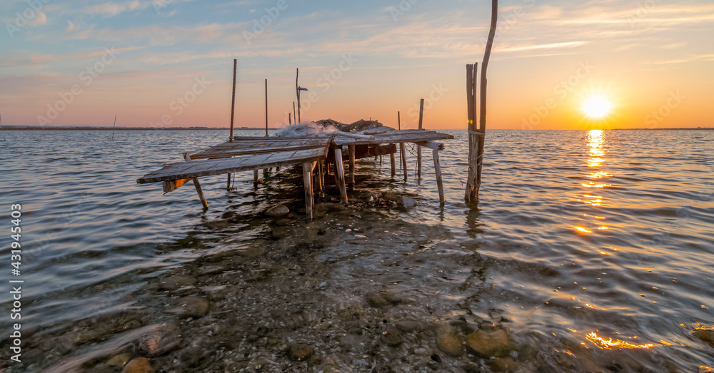 Vue d'un ponton de pêche avec un coucher de soleil sur un étang de la ...