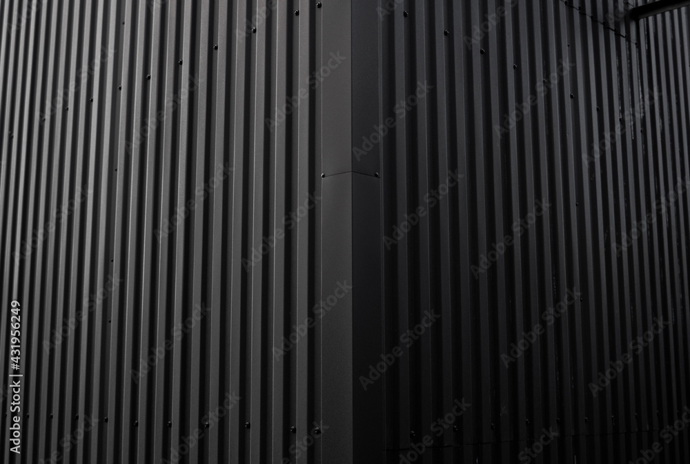 Black corrugated iron sheet used as a facade of a warehouse or factory ...