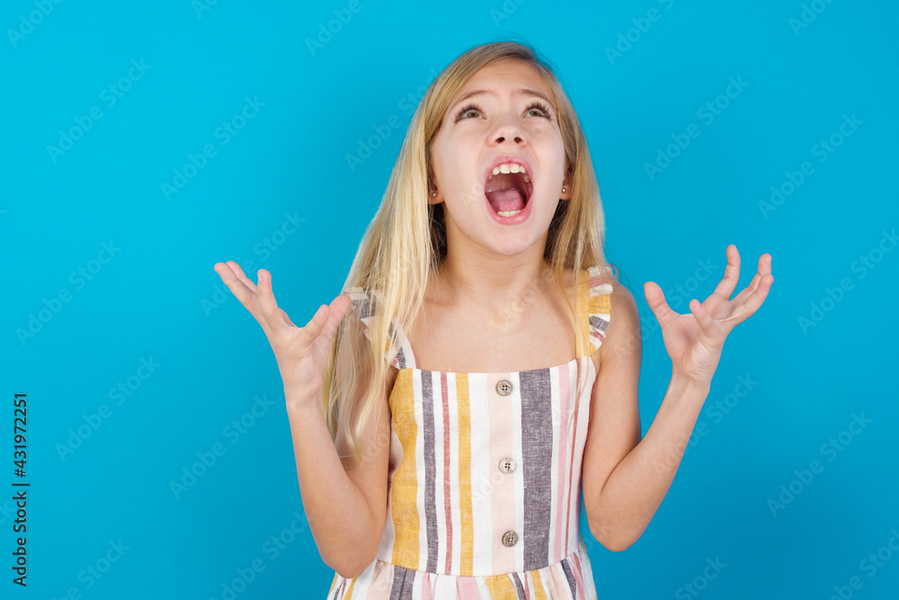 beautiful Caucasian little girl wearing stripped dress over blue ...
