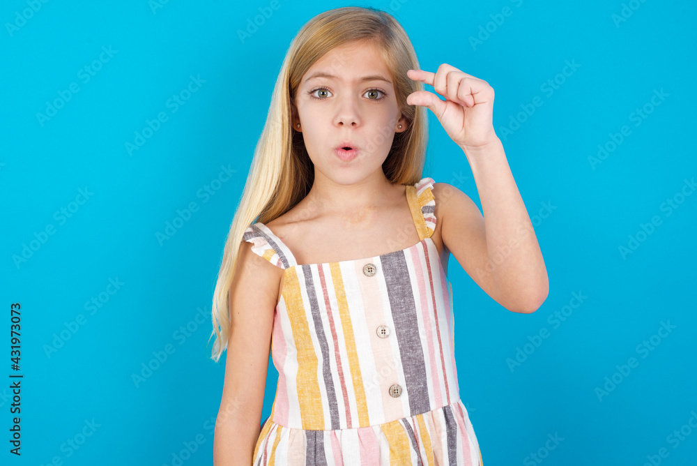 Shocked beautiful Caucasian little girl wearing stripped dress over ...