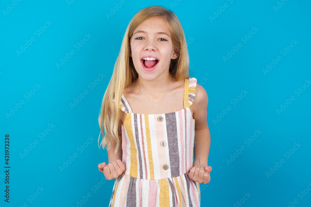 beautiful Caucasian little girl wearing stripped dress over blue ...