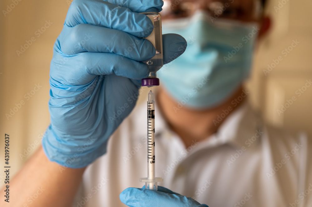 Nurse prepping for injection by drawing liquid into a syringe Stock ...