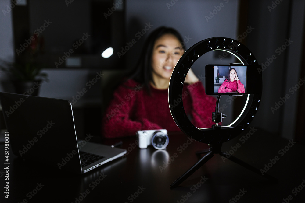 Female influencer vlogging about new camera in darkroom foto de Stock ...