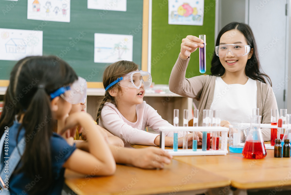 Group of little pupils with Asian female Teacher making experiment in ...