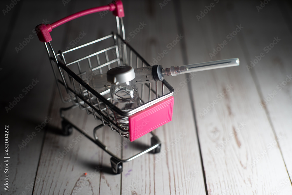 vaccine syringe vial of liquid on a shopping cart trolley showing ...