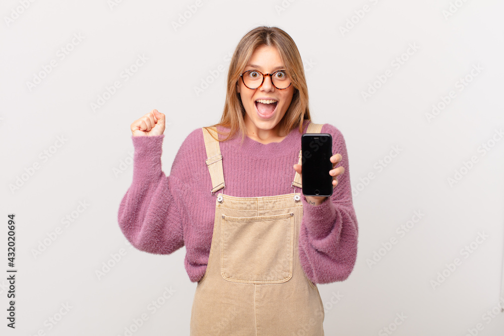young girl with a cell shouting aggressively with an angry expression ...