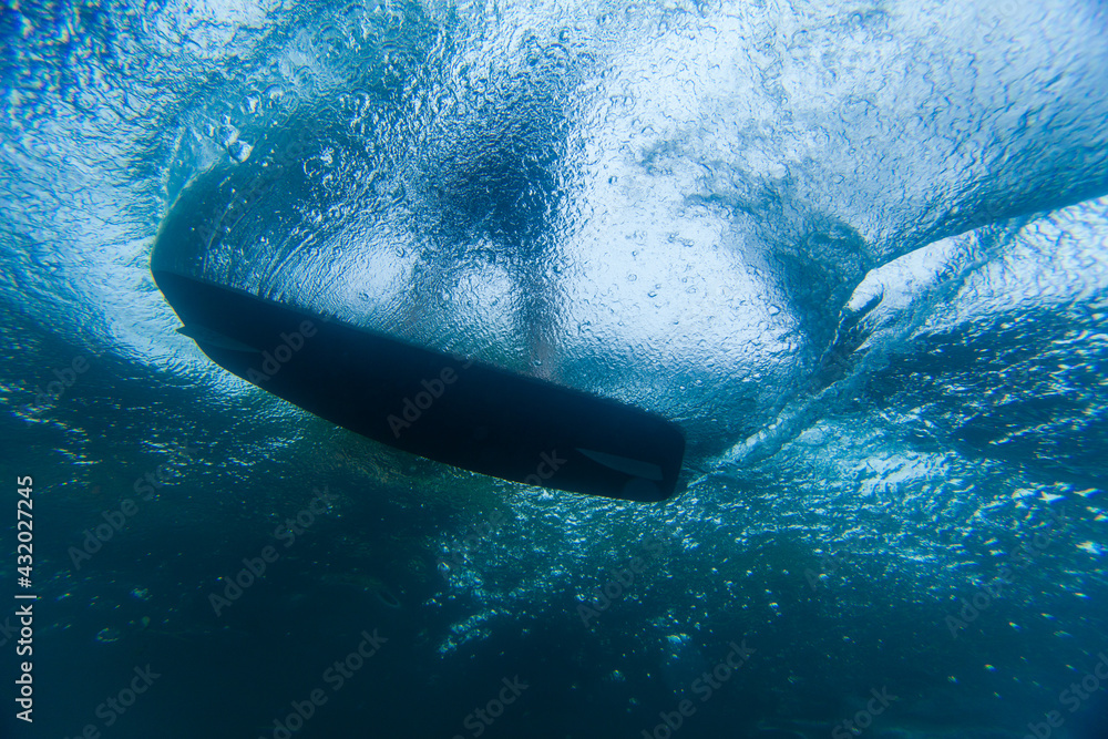 Male boarder skims across the water on a wakeboard in the summer to ...