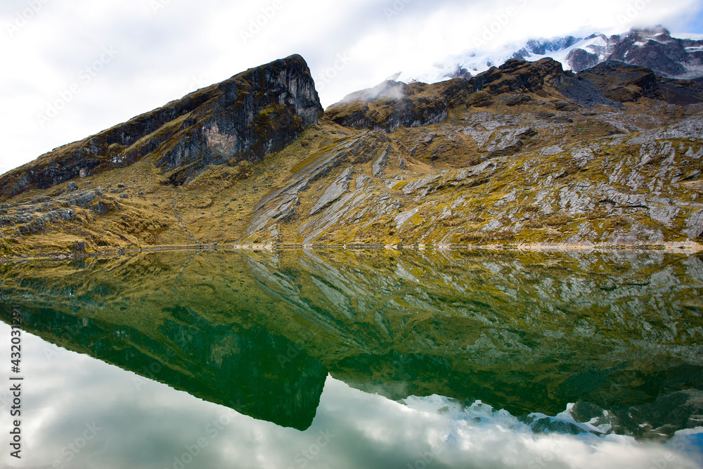 Clouds part above Chilata Lagoon as the reflection reveals granite ...