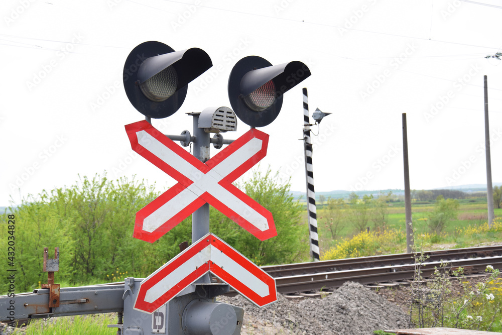 Railway level crossing with semaphore and barrier. Warning road sign on ...