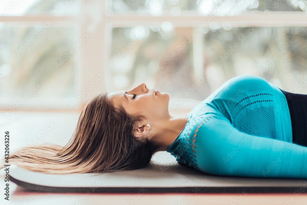 woman lying on her back relaxed in a meditation session. she is calm ...