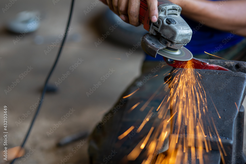 Young workers use metal grinders Steel parts of a motorbike To design ...