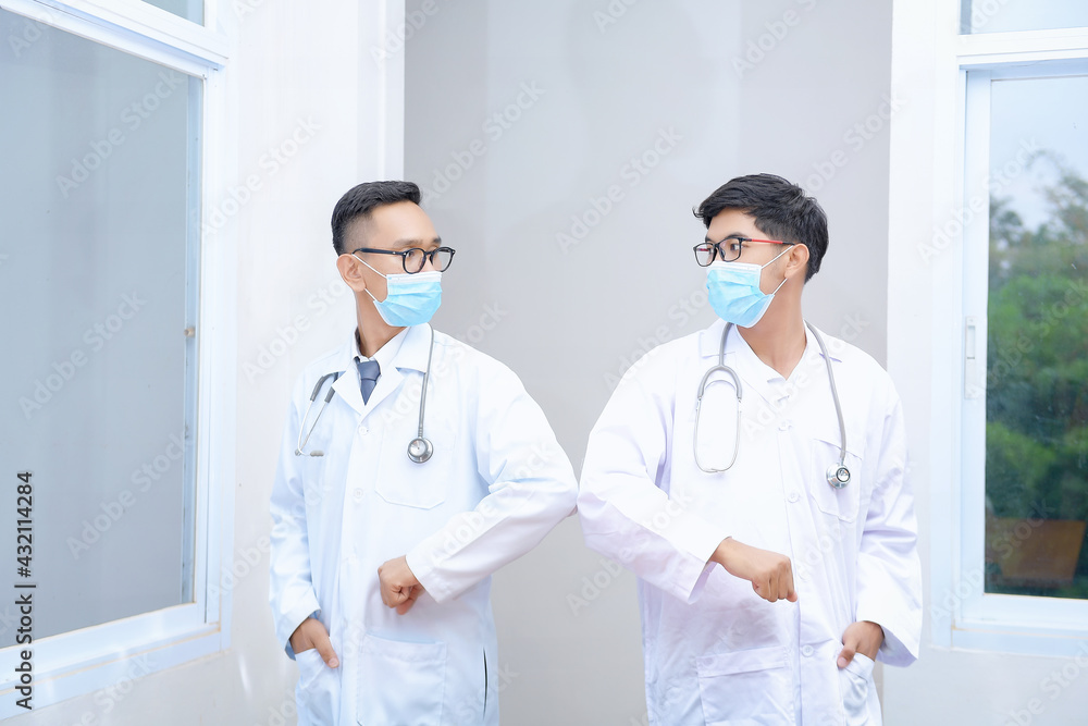 Portrait of two doctors greeting each other by bumping elbows Stock ...