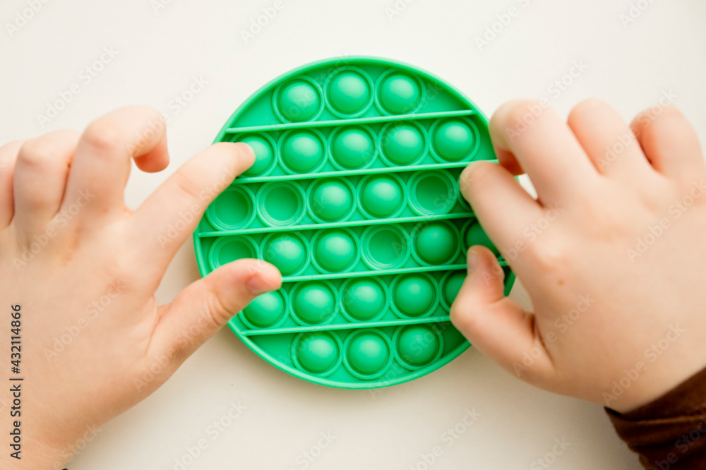 Close up shot of kids fingers on pop it fidget toy. Instrument for ...