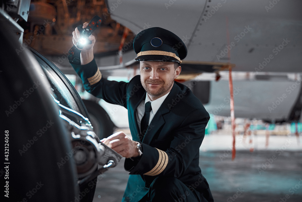 profesol confident pilot is checking plane in hangar Stock Photo ...