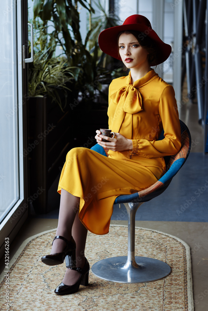 Foto Stock girl in a cafe with a cup of coffee and a hat.portrait of ...