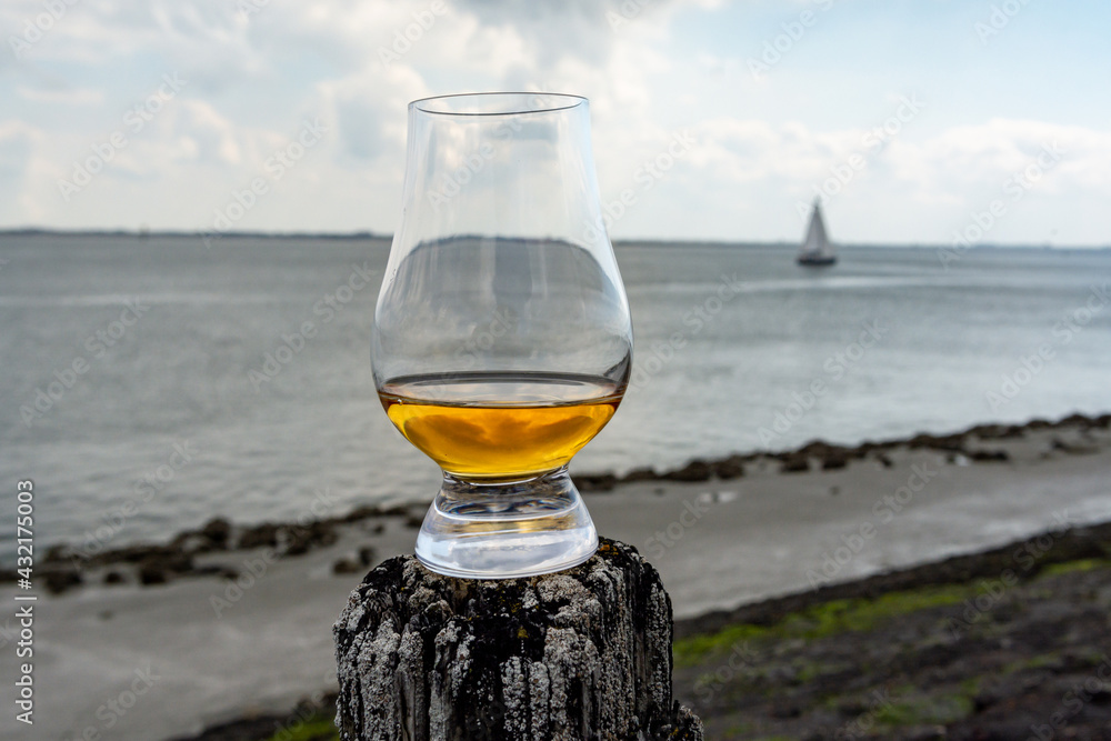 Tasting of dram single malt scotch whisky on seashore in Scotland, old ...