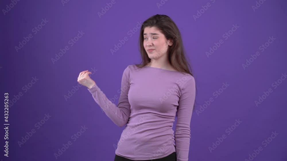 The confused young woman asks what it is, pointing with her hand from ...