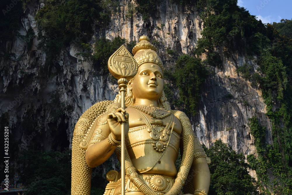 Golden statue of Lord Murugan Hindu deity in front of the Batu Caves ...