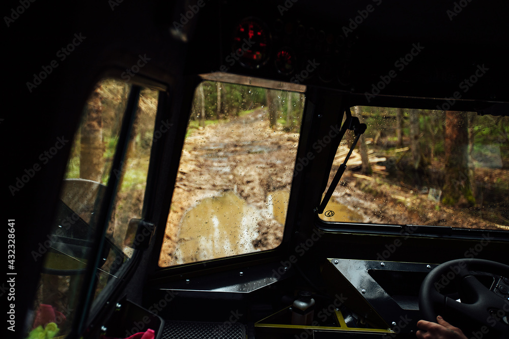 the driver is driving off-road. view from the interior of a four-wheel ...