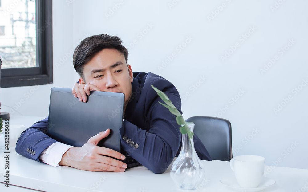 Asian lazy handsome business working man sitting, hugging laptop and ...