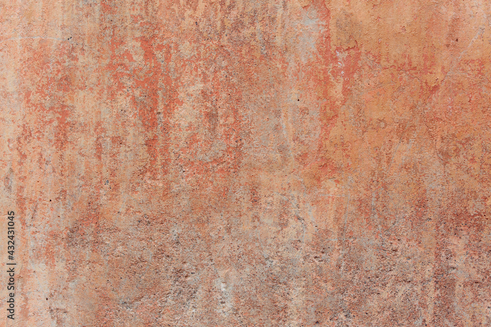 A red-yellow fragment of a concrete wall with a copious amount of ...