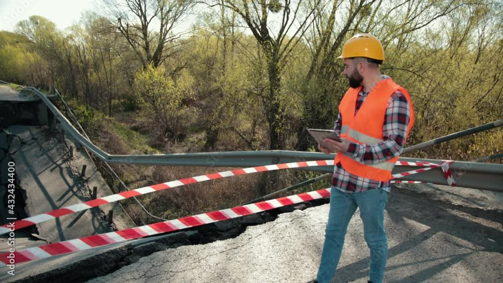 An engineer in an orange vest and a construction control helmet ...