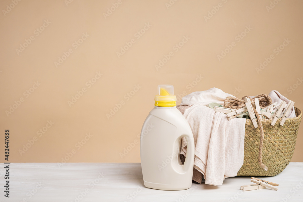 Washing mockup beige background. A basket of colored laundry, a ...