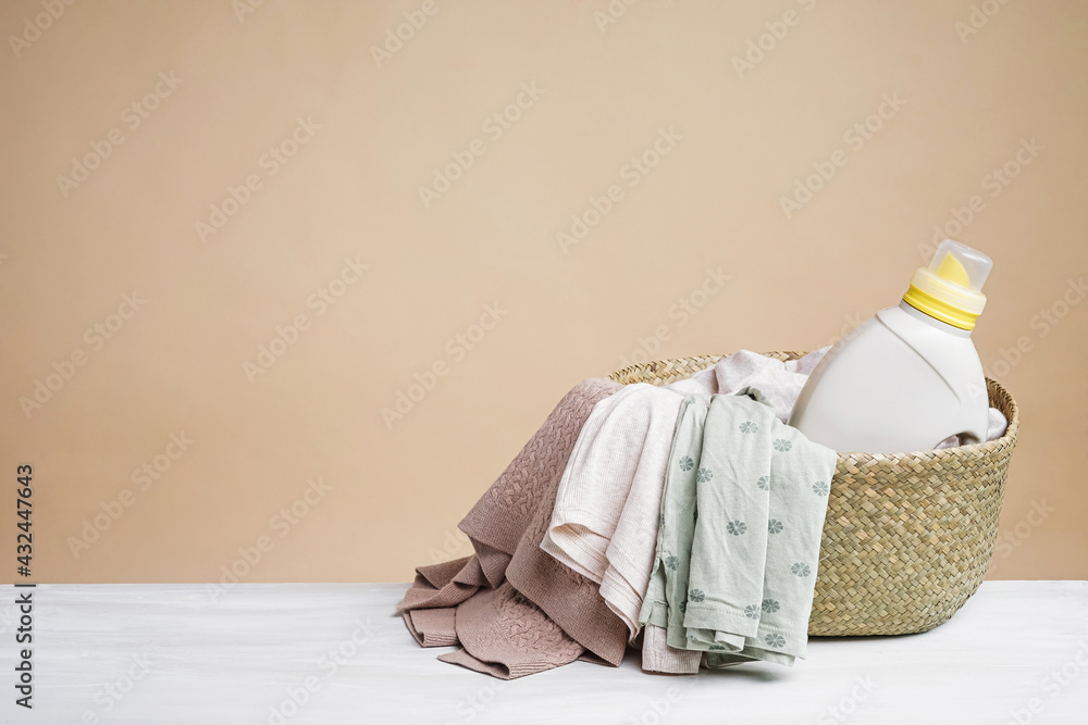 Washing mockup beige background. A basket of colored laundry, a bottle ...