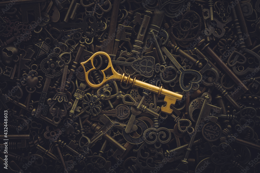 Unique gold key on pile of vintage skeleton keys. Concept for ...
