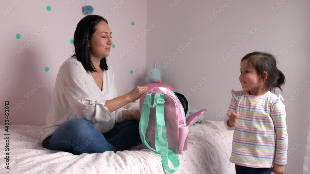 Affectionate mother getting her child ready for her first day at school ...