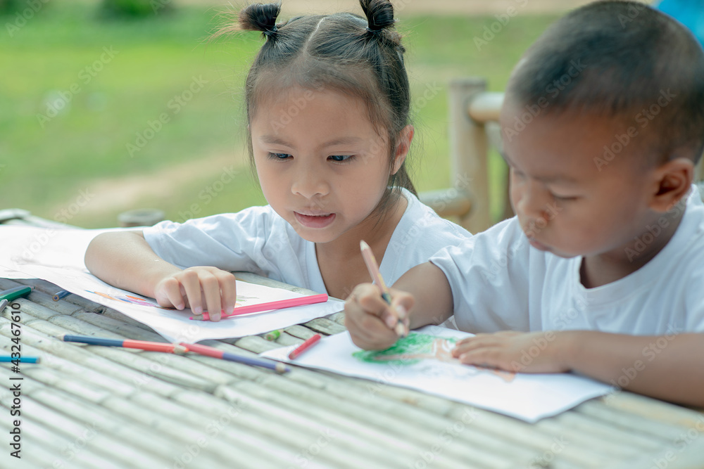 Happy cheerful child drawing using a pencil drawing some ideas while ...