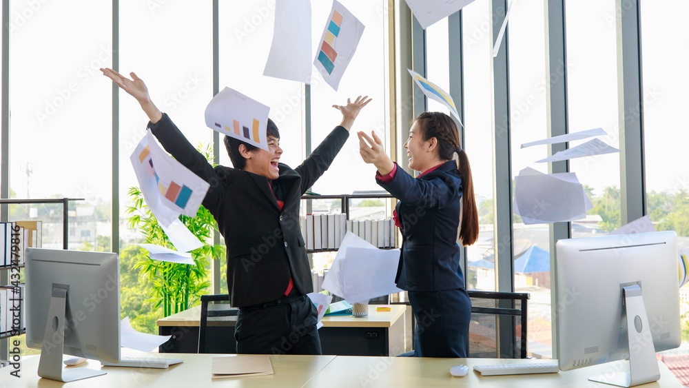 Businessman and businesswoman standing in office and throwing document ...