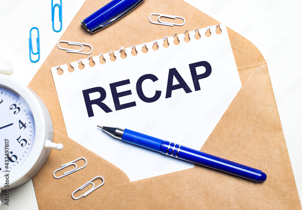 On a light background, a craft envelope, an alarm clock, paper clips, a ...