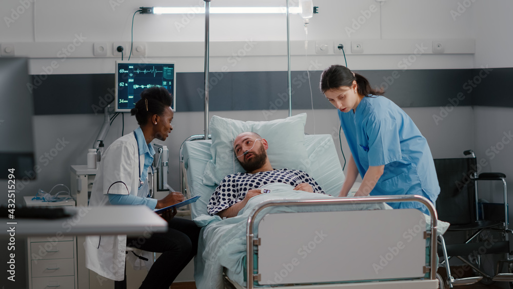 Patient talking with medical doctors while sitting in bed during ...