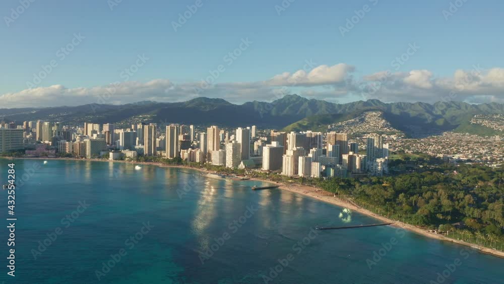 Panning aerial drone slowly flying over a colorful Honolulu Skyline ...