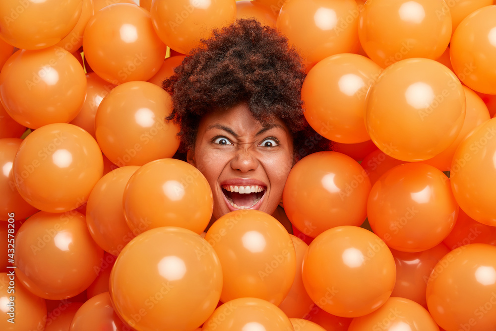 Emotional dark skinned curly woman smirks face has crazy expression ...