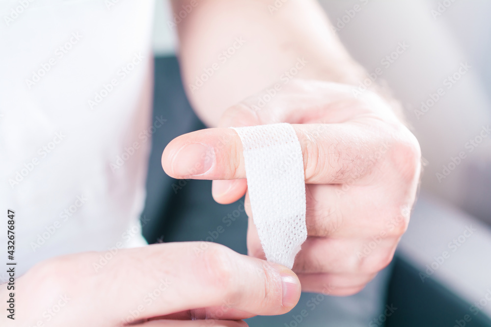 Guy Applying A White Plaster To A Wound On His Finger Stock Photo ...