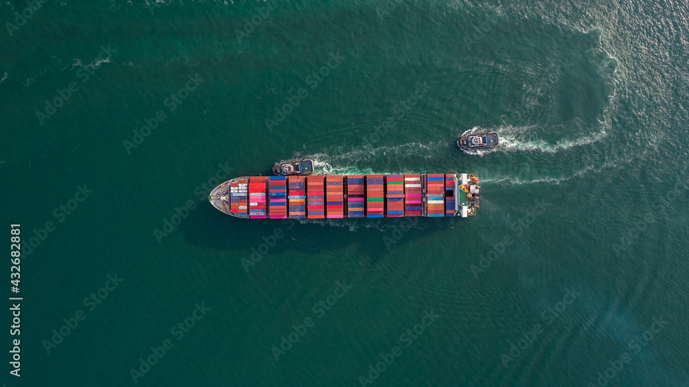 Aerial top view of cargo ship carrying container with tug boat and ...