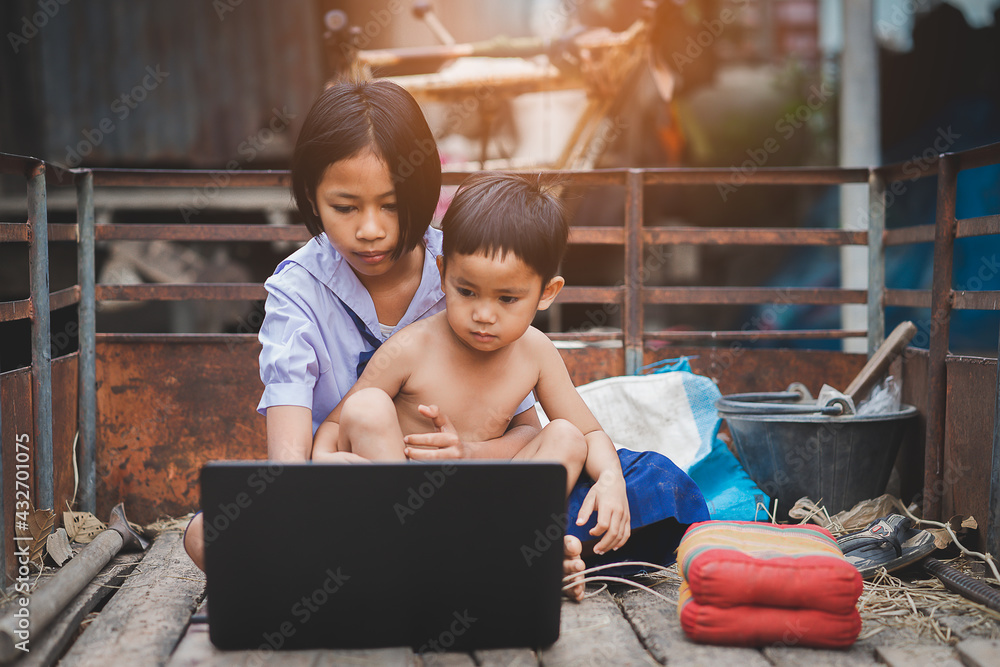 Asian uniform student girl and younger brother using computer laptop ...