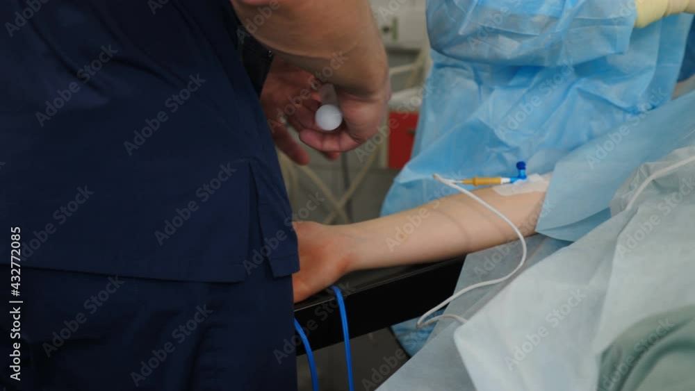 Female patient is under anesthesia in hospital. hand of patient under ...