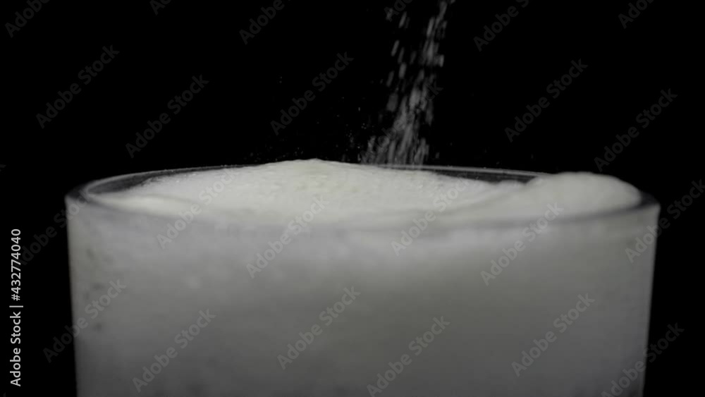 Powdered medicine being put / mixed with water in a clear glass ...
