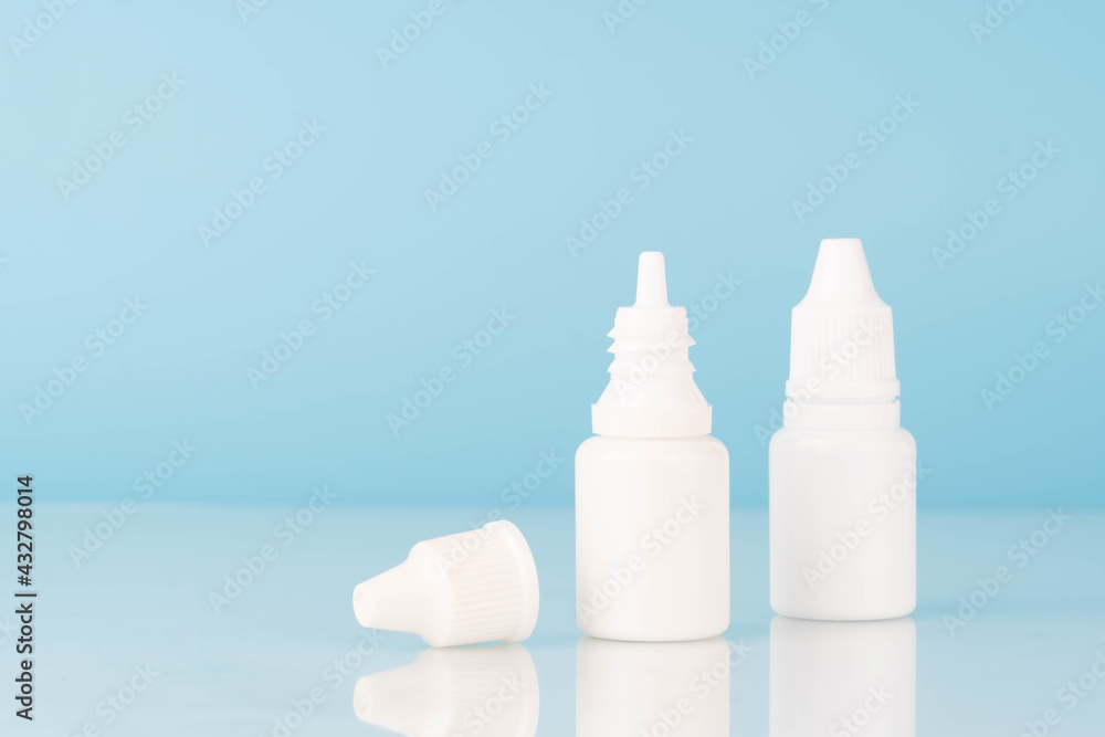 Eye drop or ear drop bottles on light blue background. Blank white ...